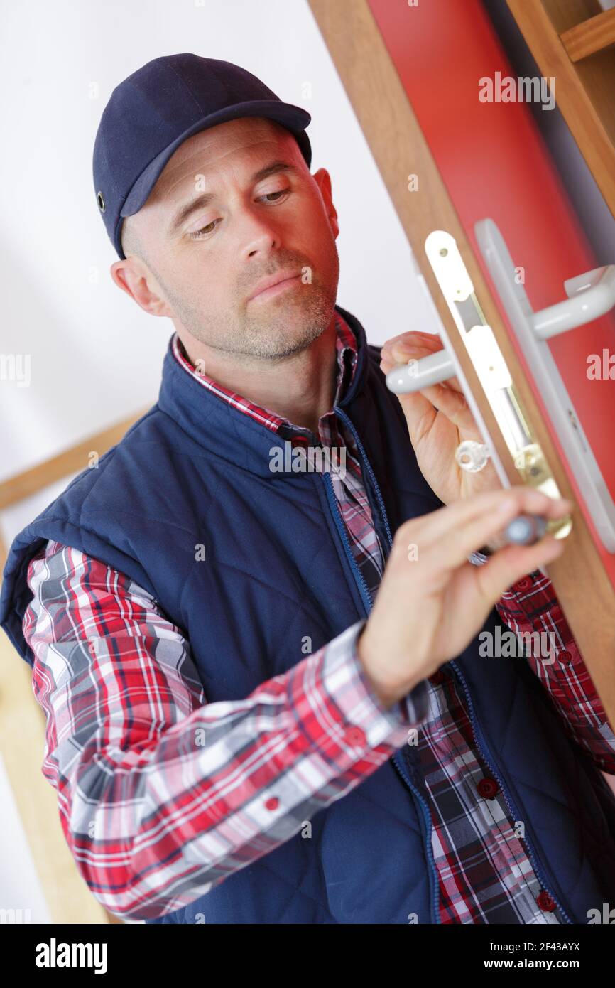 man fixing a door lock Stock Photo - Alamy