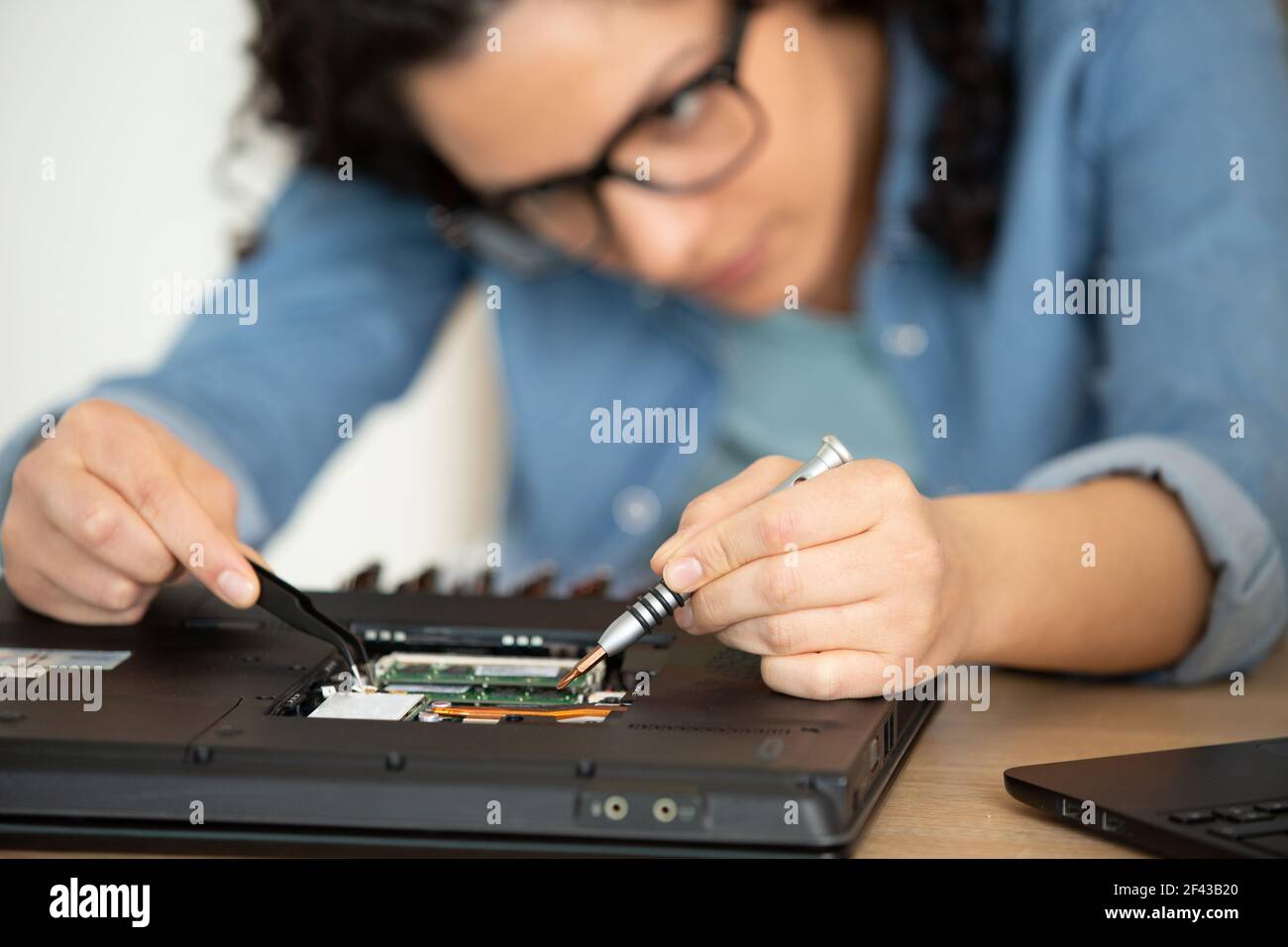 concentrated woman fix pc component in service center Stock Photo - Alamy