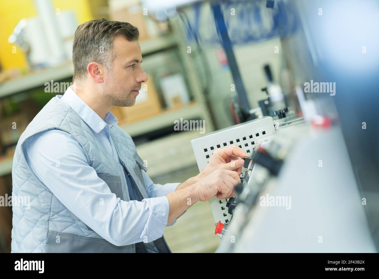 skilled worker operating a manufacturing machine Stock Photo - Alamy