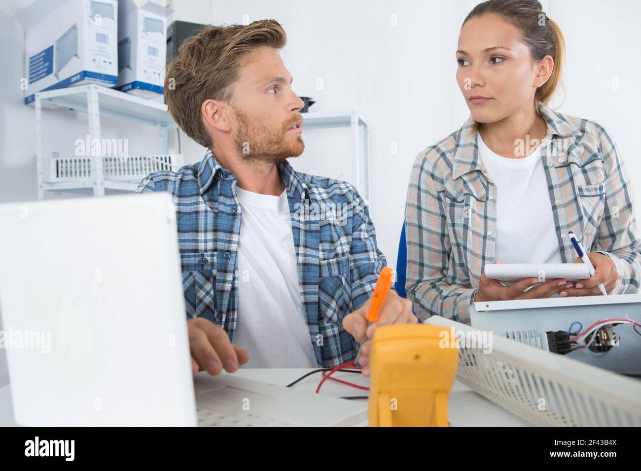 couple fixing an electronic device Stock Photo - Alamy