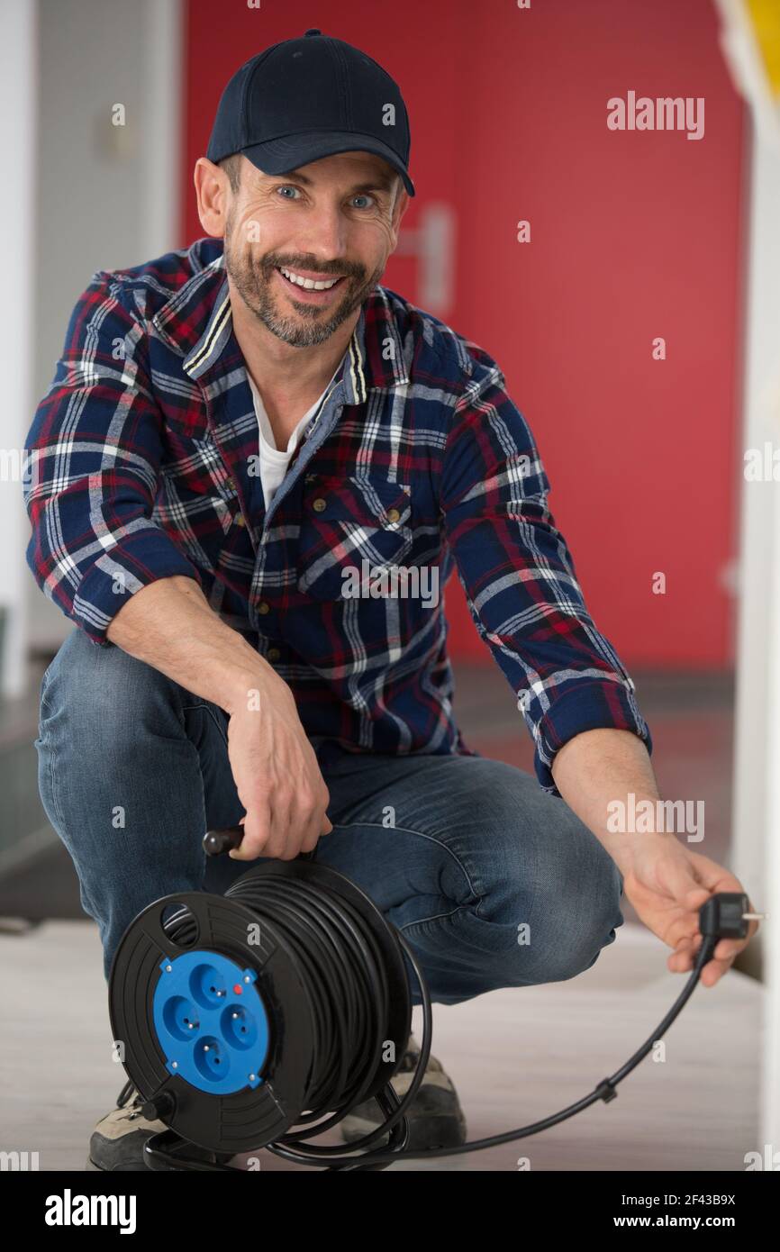 man plugging in an extension lead on a reel Stock Photo - Alamy