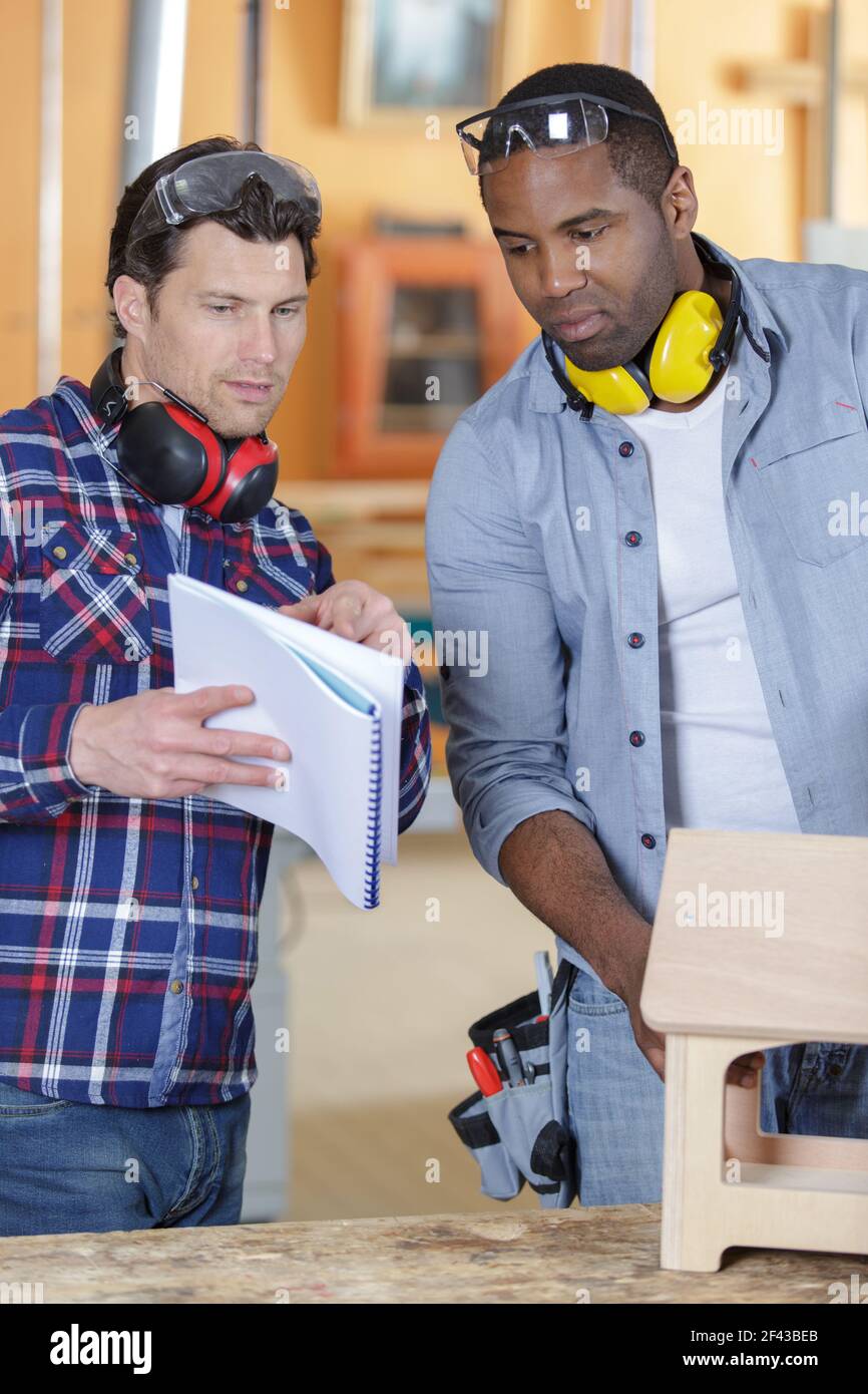 carpenter teaching apprentice how to build bird house Stock Photo - Alamy
