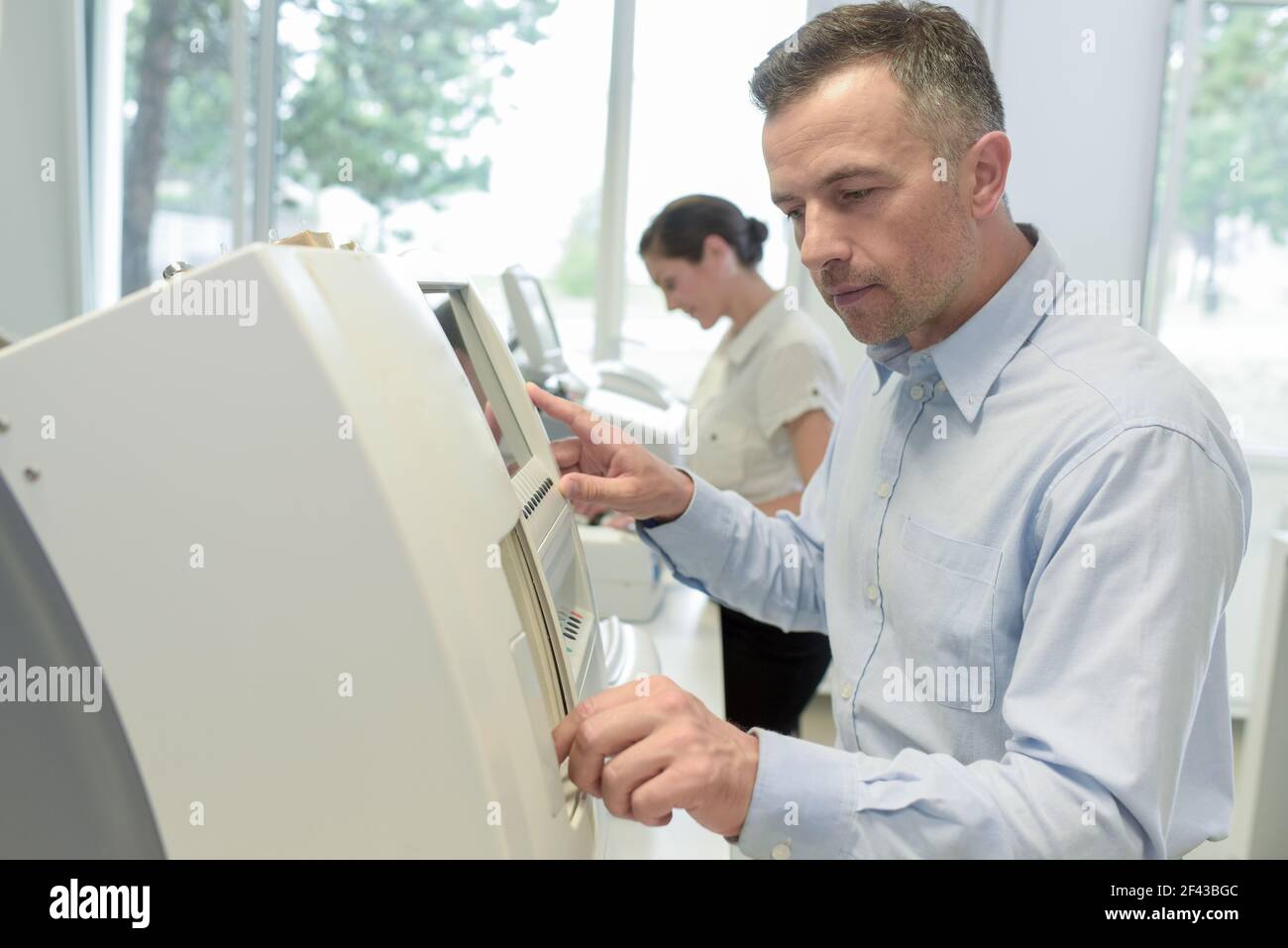 man at a atm cash machine Stock Photo - Alamy