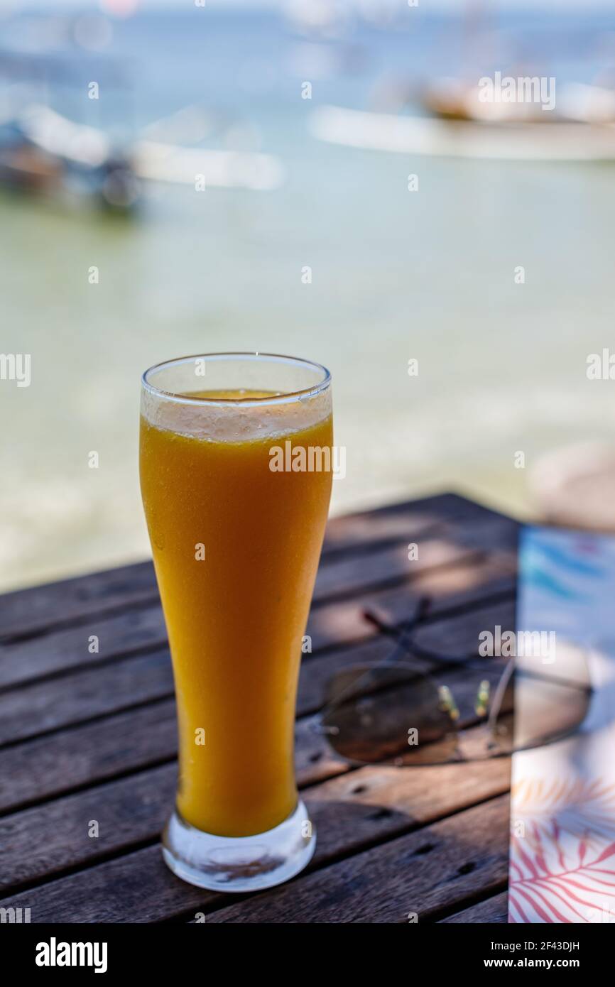 Mango juice on the beach with the sea on the background. Sanur, Bali ...