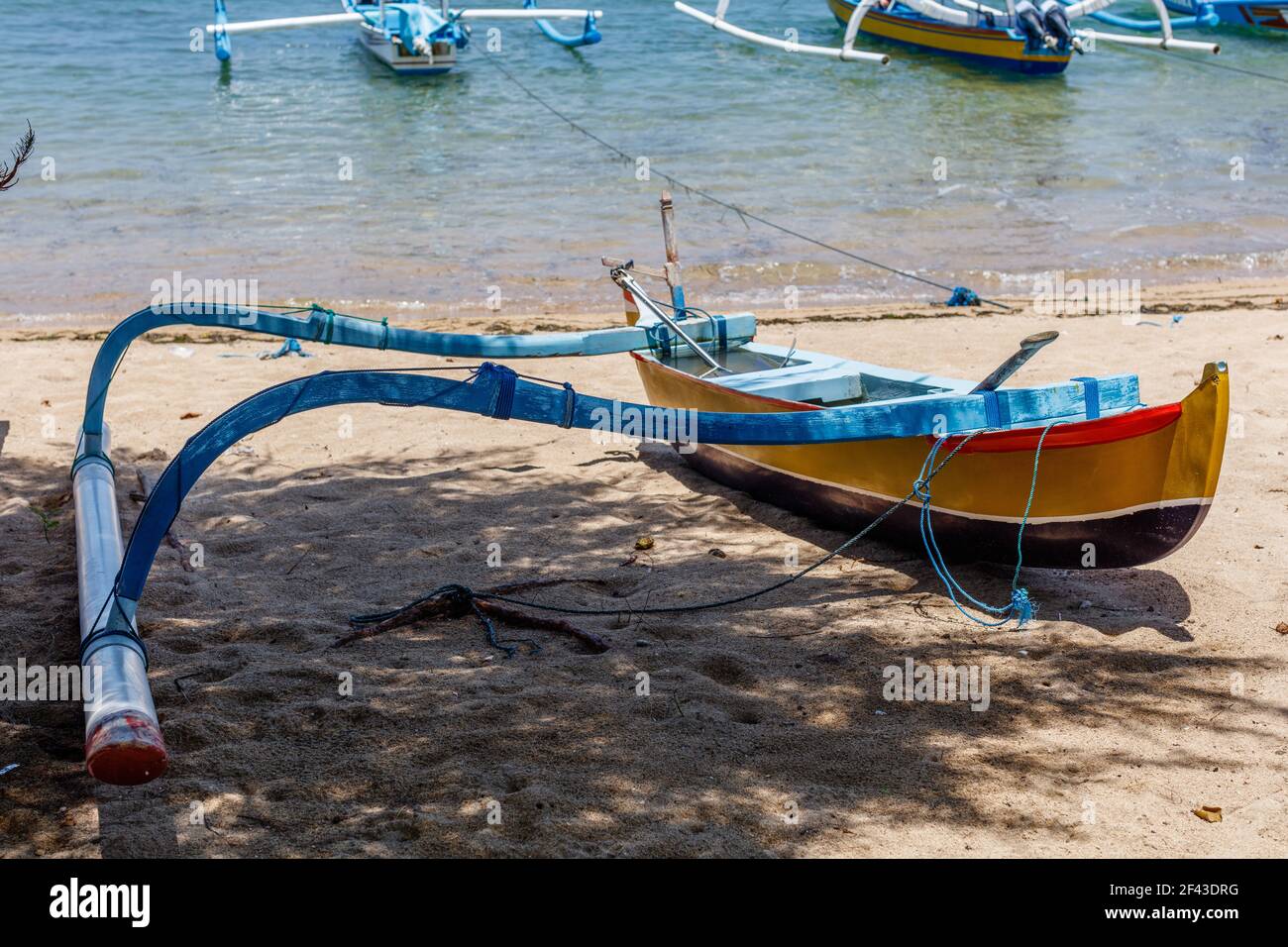 Traditional Indonesian outrigger style wooden fishing boat (jukung) on ...