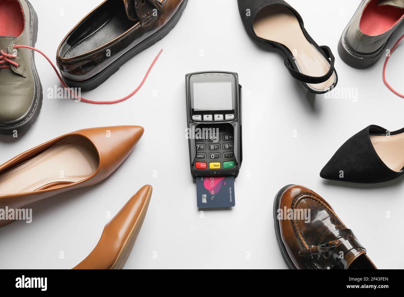 Payment terminal with credit card and different shoes on white ...