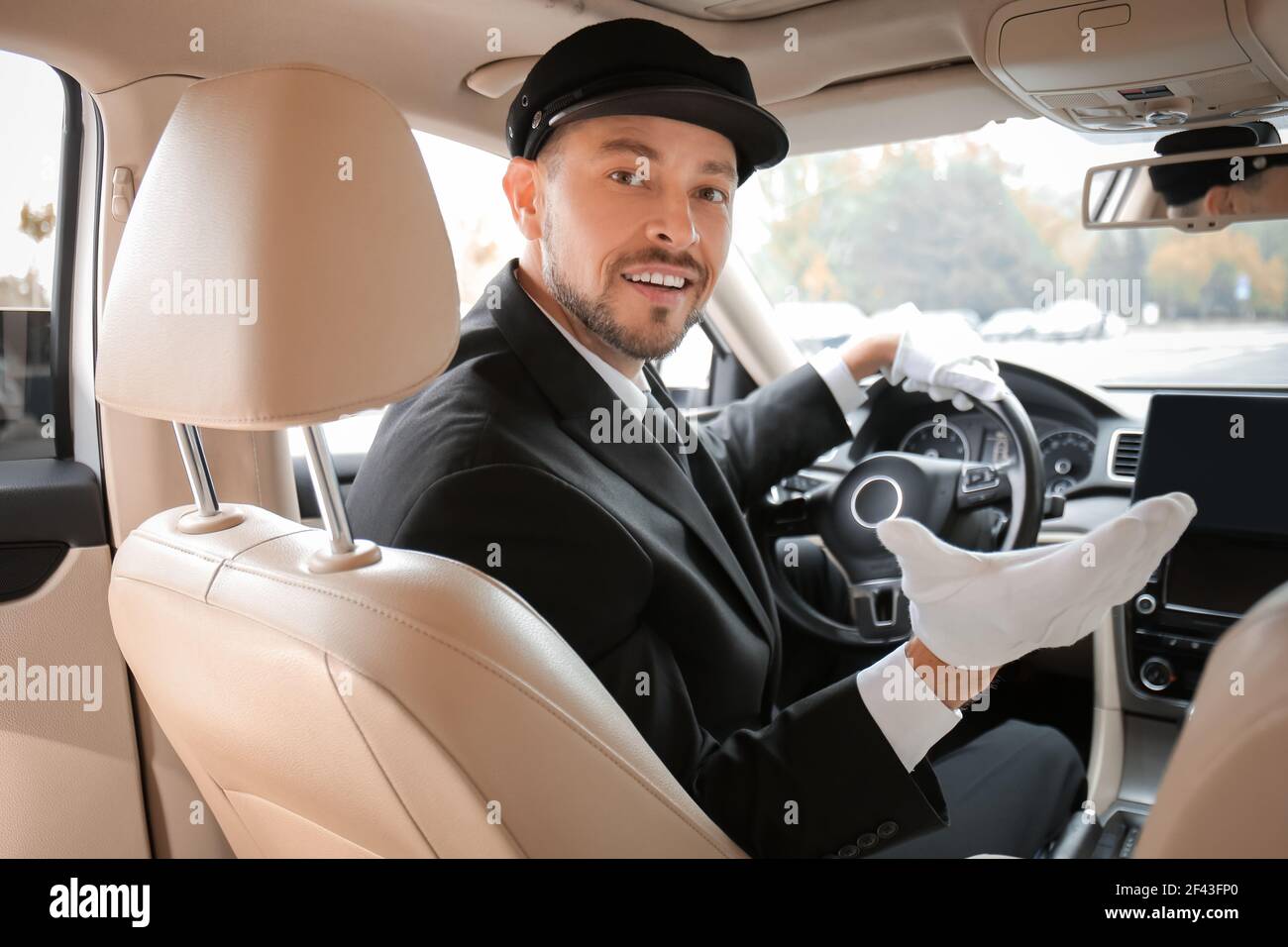 Handsome chauffeur driving luxury car Stock Photo - Alamy