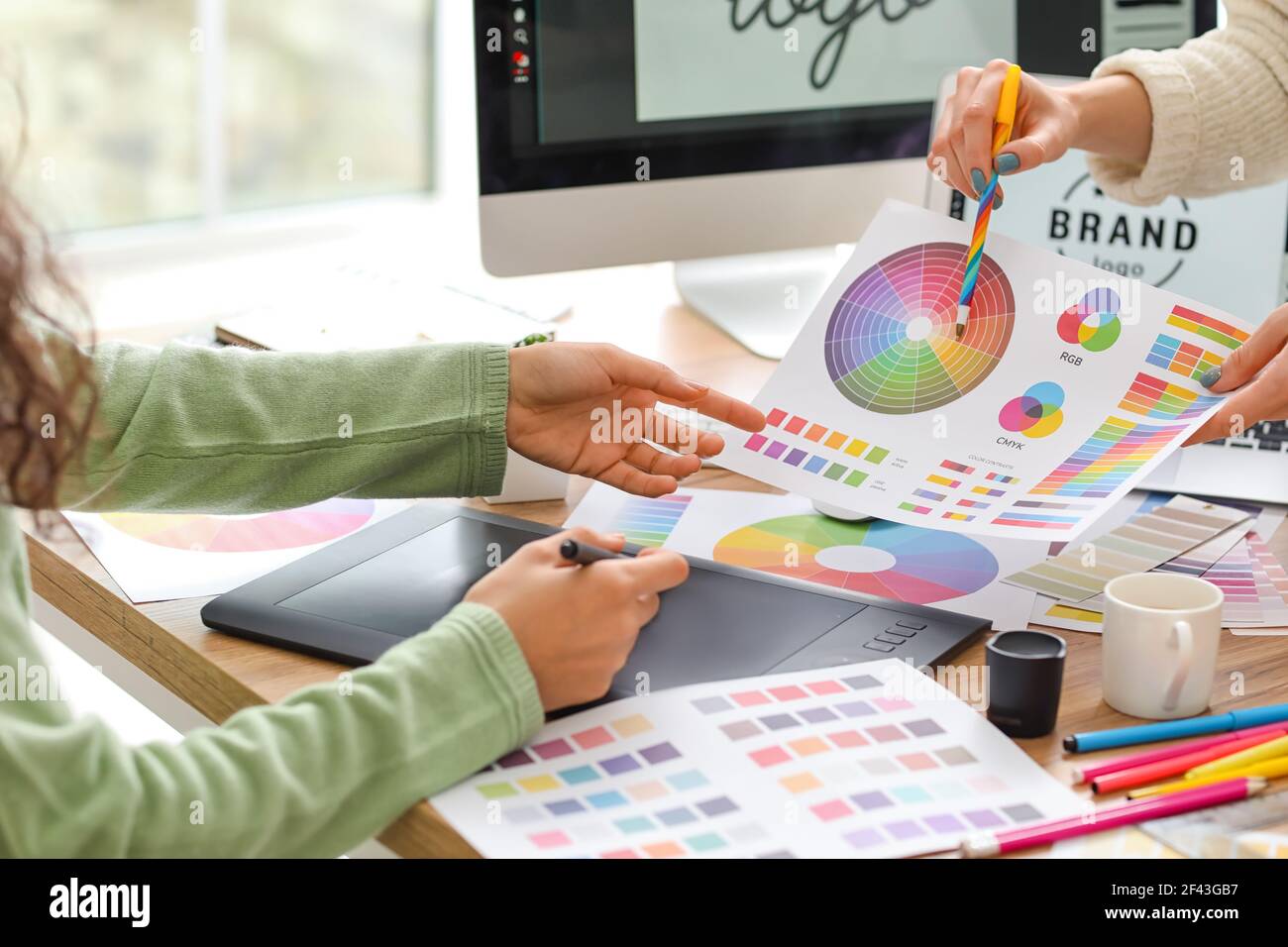Graphic designer with colleague working in office Stock Photo - Alamy
