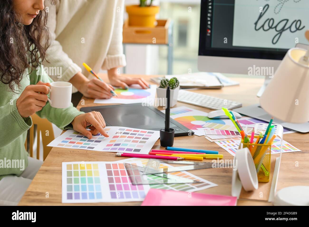 Graphic designer with colleague working in office Stock Photo - Alamy