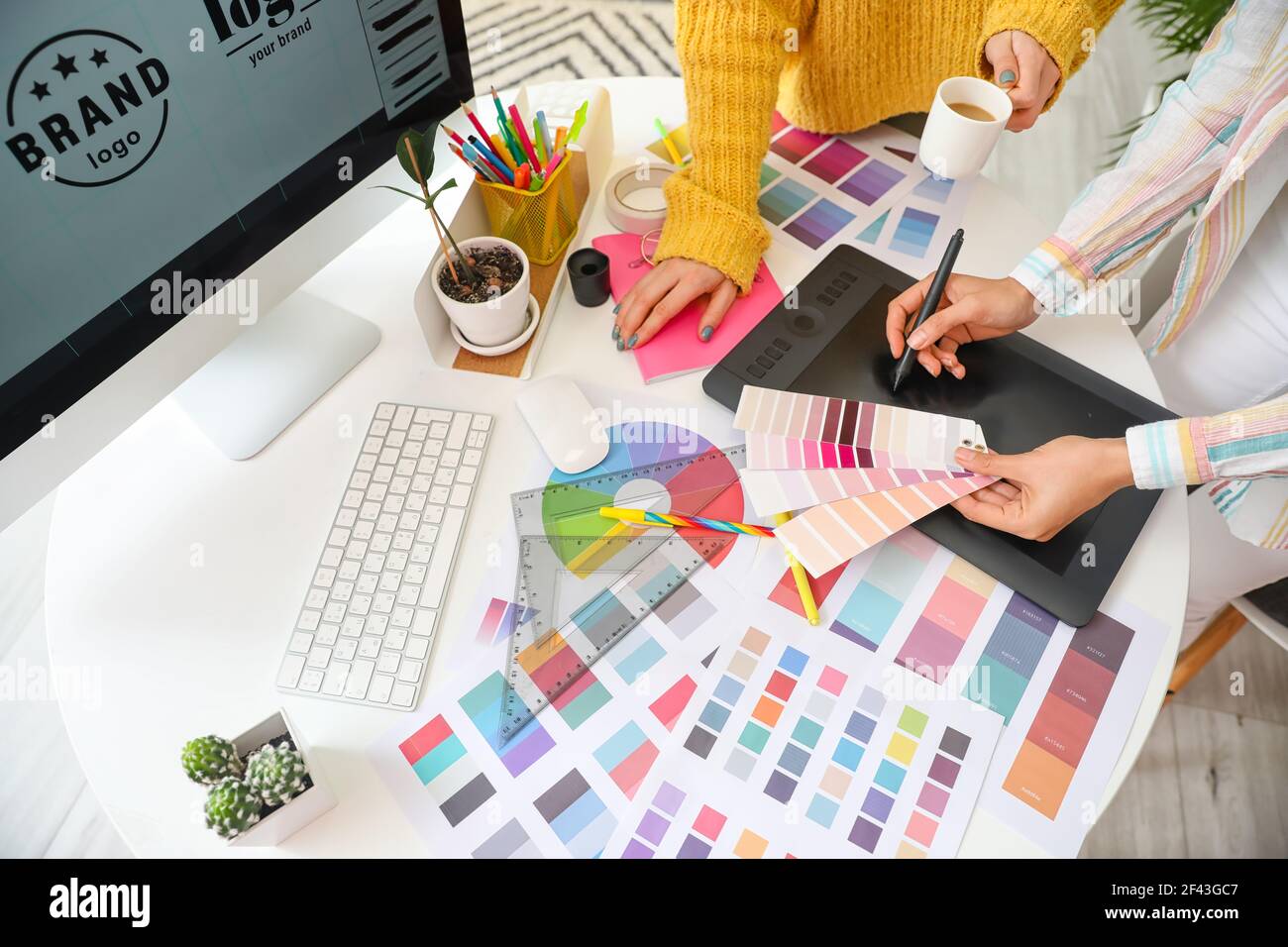 Graphic designer with colleague working in office Stock Photo - Alamy