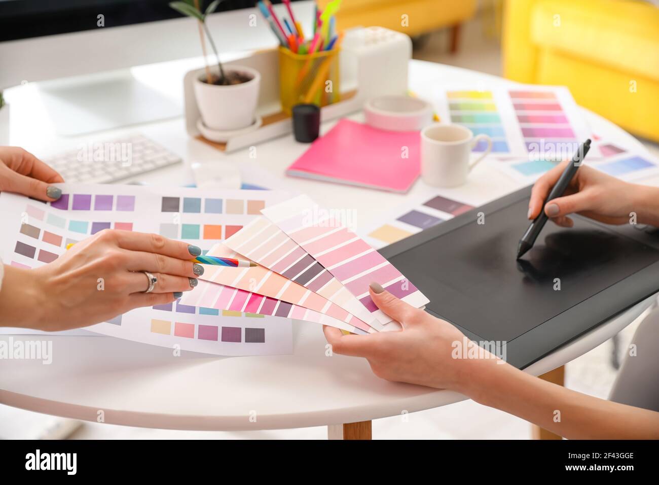 Graphic designer with colleague working in office Stock Photo - Alamy