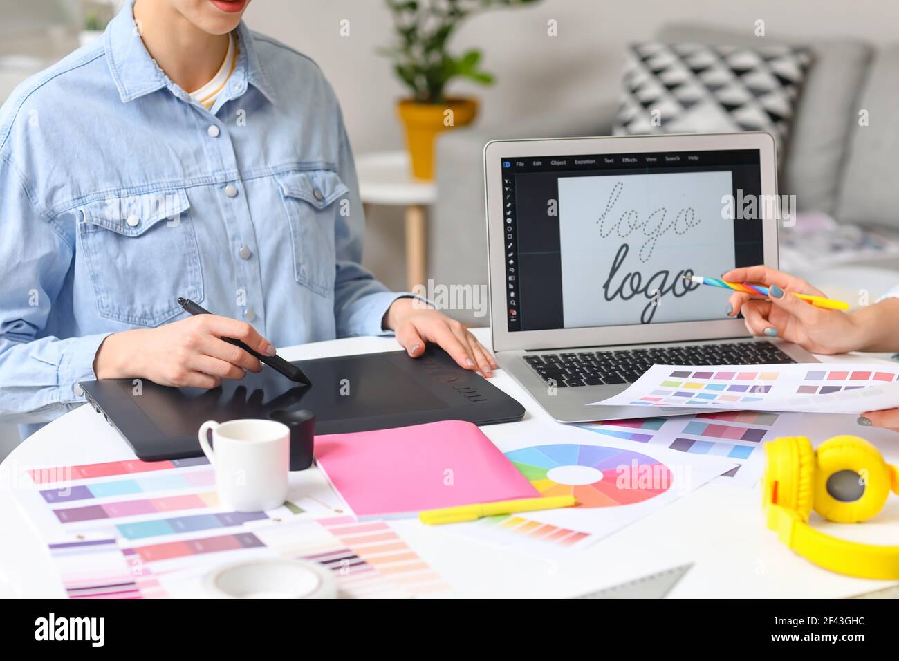 Graphic designer with colleague working in office Stock Photo - Alamy