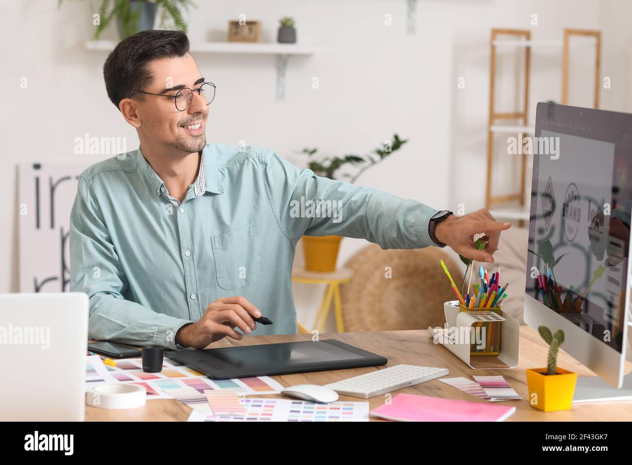Graphic designer working in office Stock Photo - Alamy