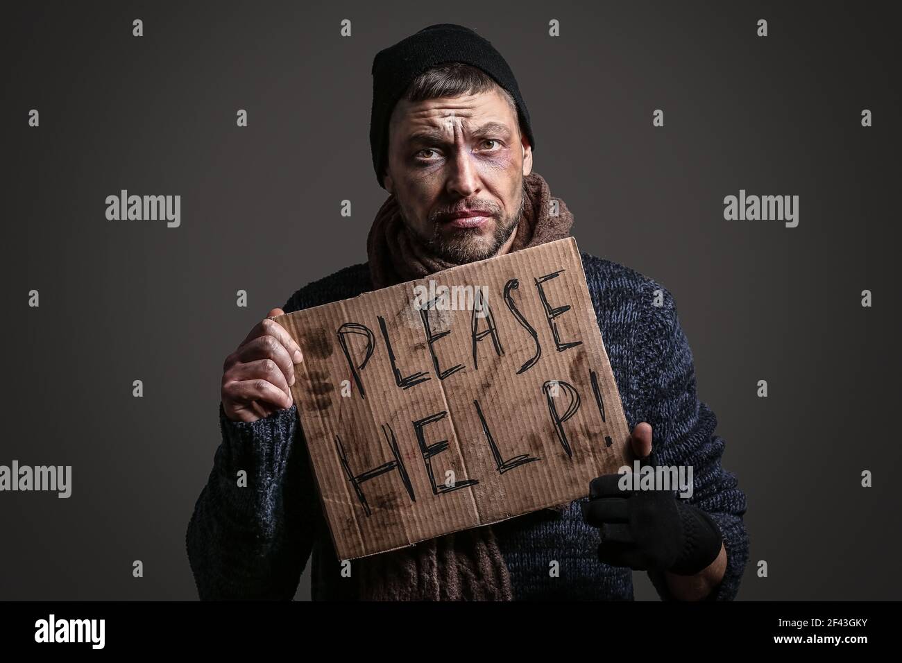 Portrait of begging homeless man on dark background Stock Photo - Alamy