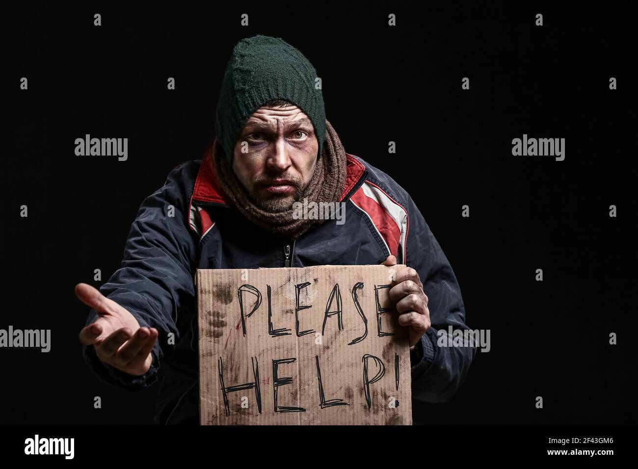 Portrait of begging homeless man on dark background Stock Photo - Alamy