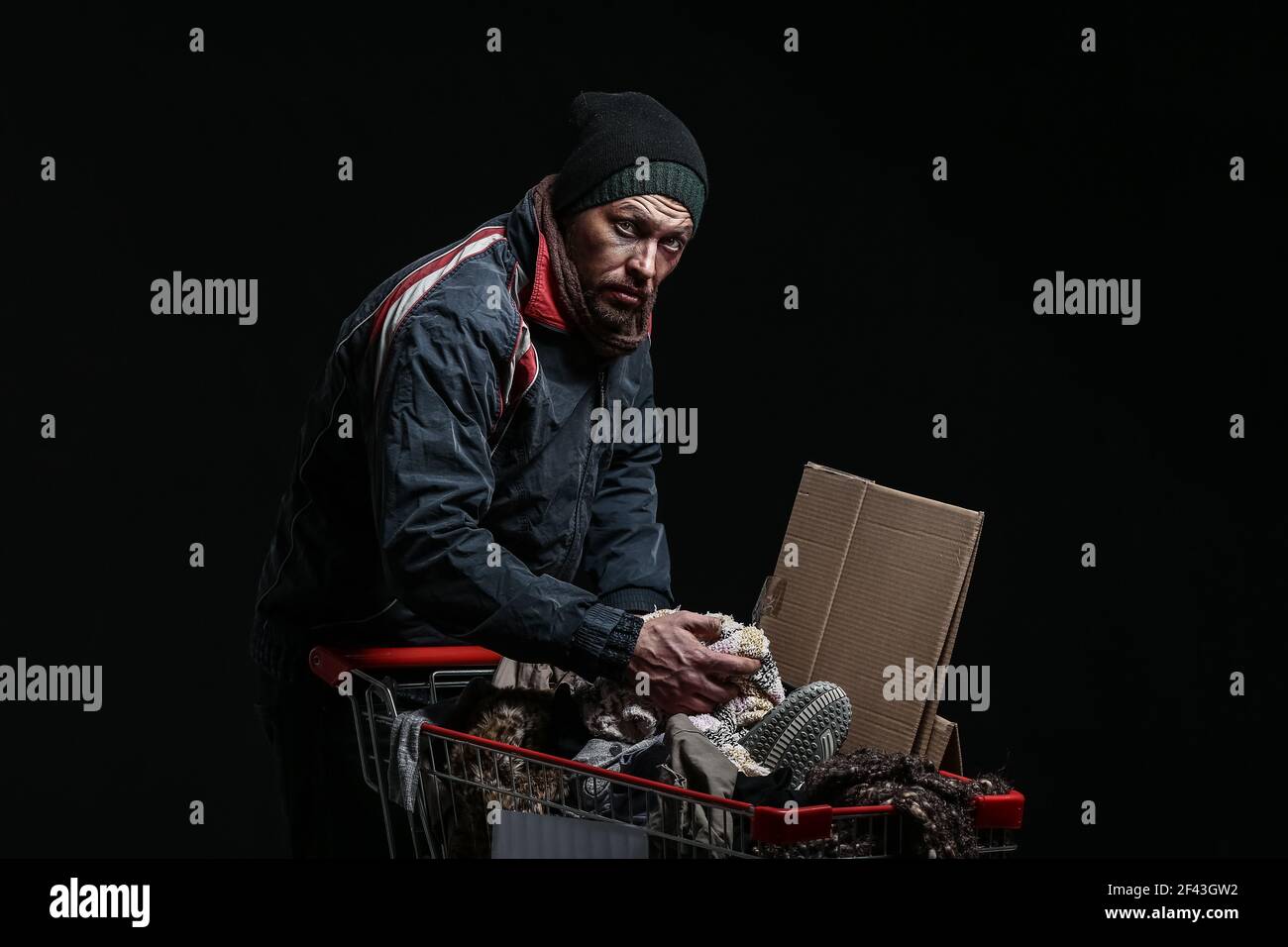 Poor homeless man with donations on dark background Stock Photo - Alamy
