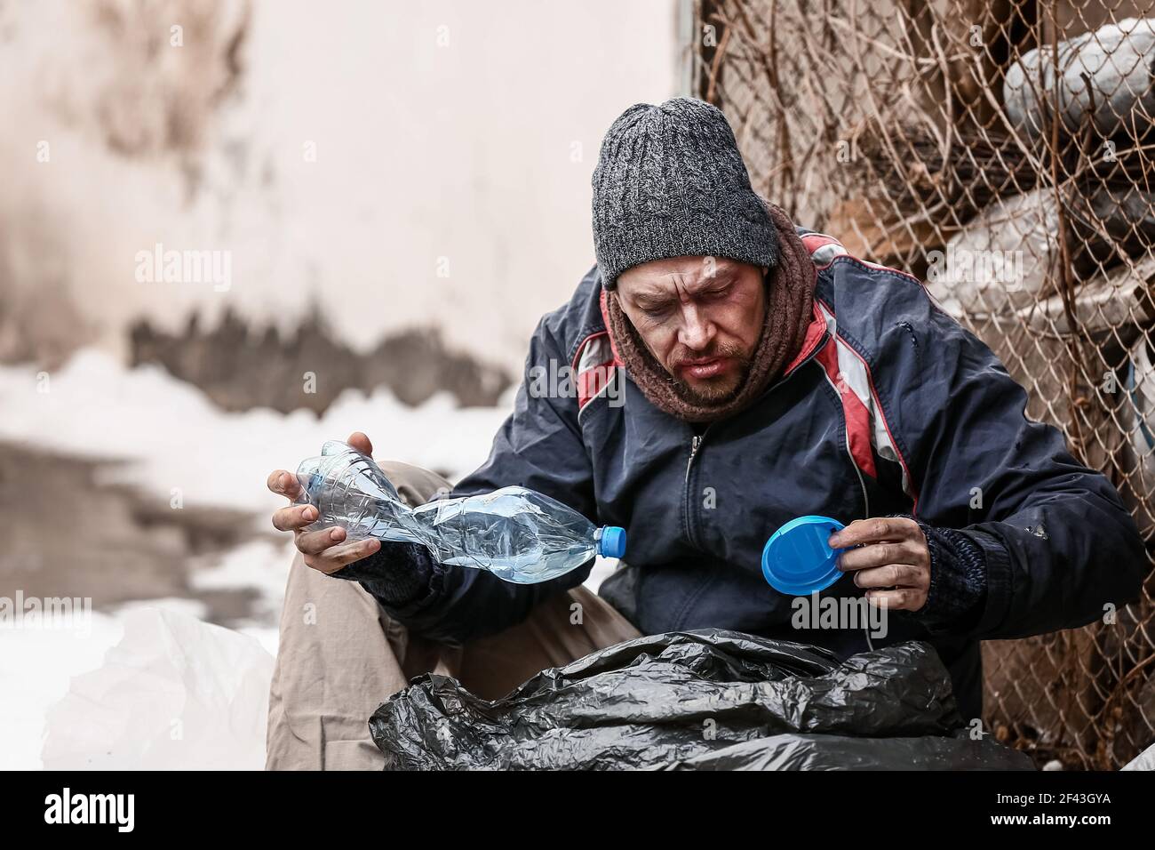 Poor homeless man with trash bag outdoors on winter day Stock Photo - Alamy