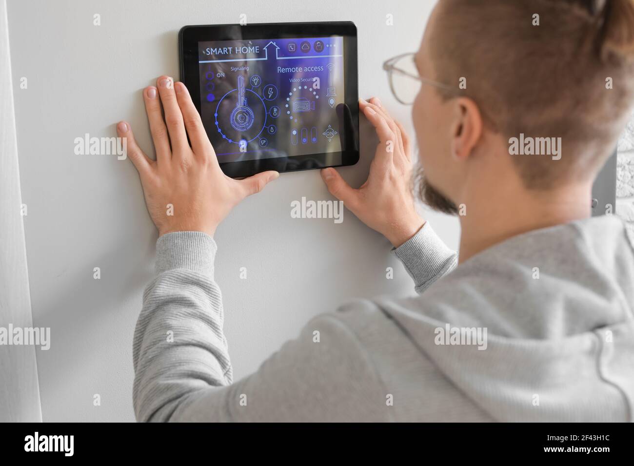 Man using smart home security system control panel Stock Photo - Alamy