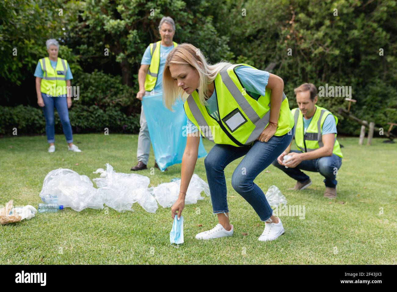 Caucasian woman picking up face mask with group of men and women ...