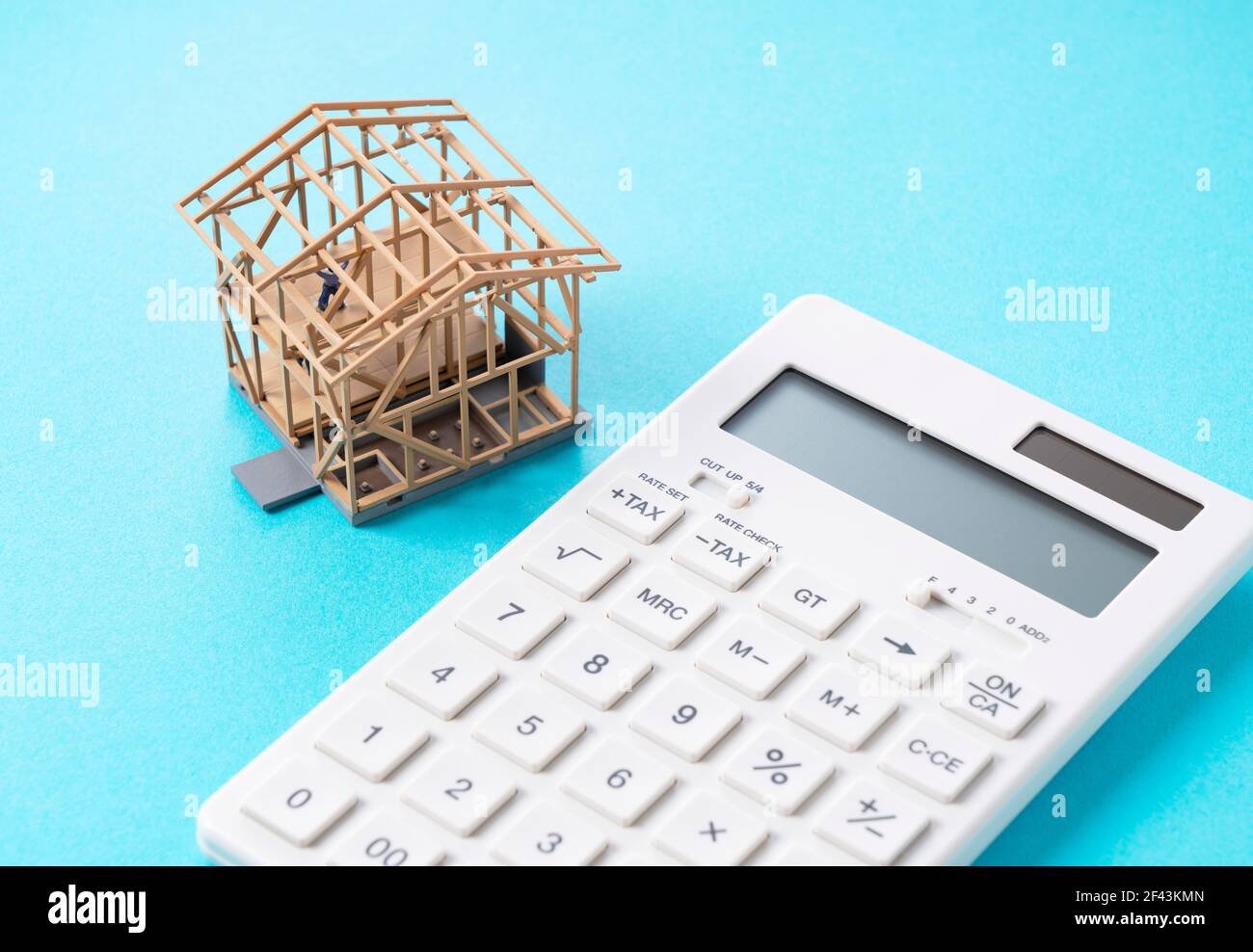 A model of a house and a calculator on a blue background. Business ...