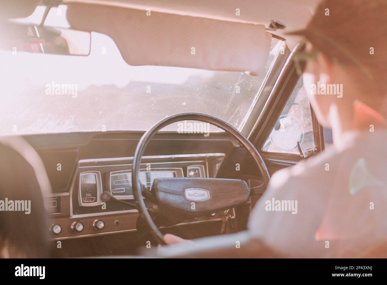 Man driving ford valiant golden hour with cap and sunglasses classic ...