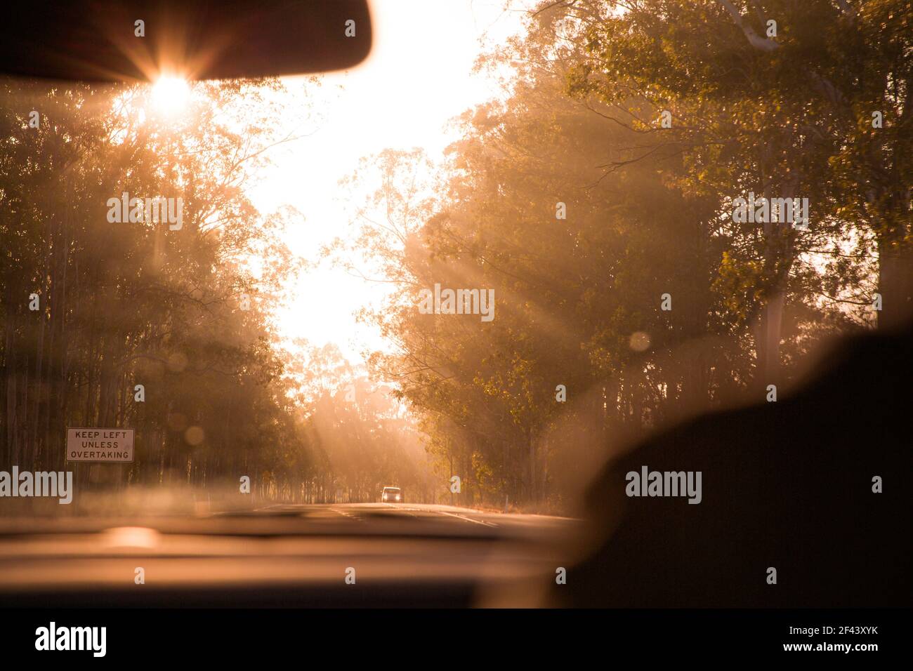 Golden morning sunrays shining down on Australian country highway on a ...