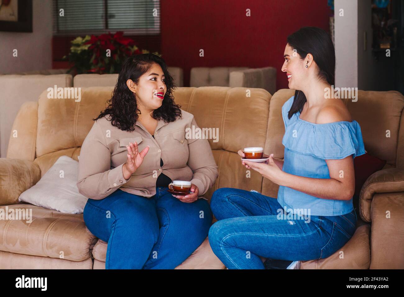 Three happy latin friends women talking and drinking coffee and tea ...