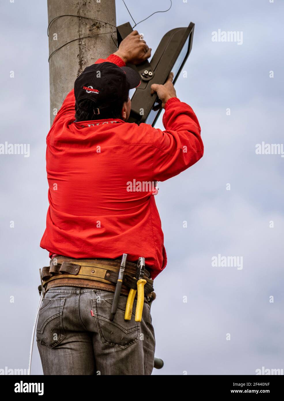 Workman attaches LED lgiht to pole for festival Stock Photo - Alamy
