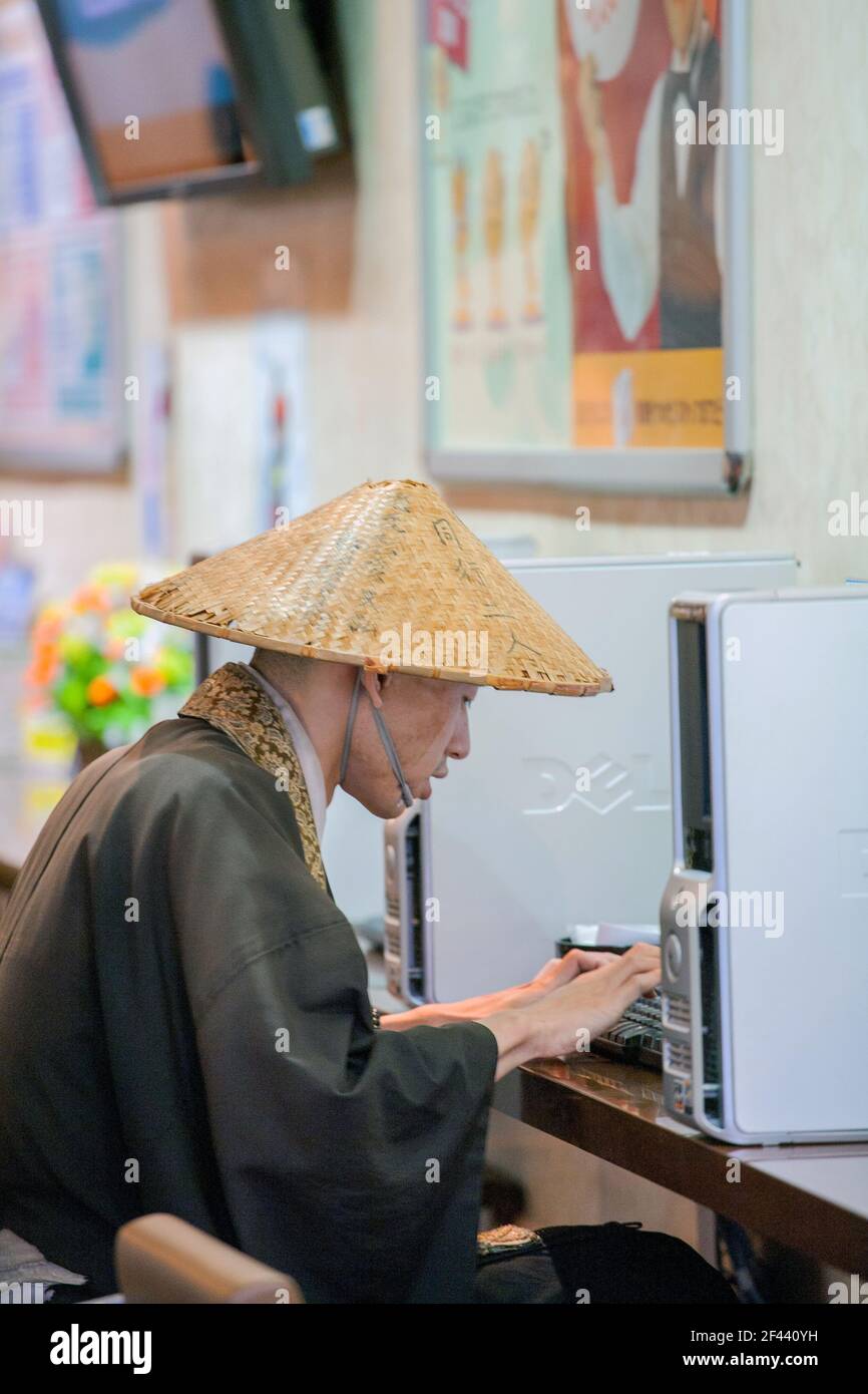 Japanese Buddhist Monk using computer in Ginza cafe, Tokyo, Japan Stock ...
