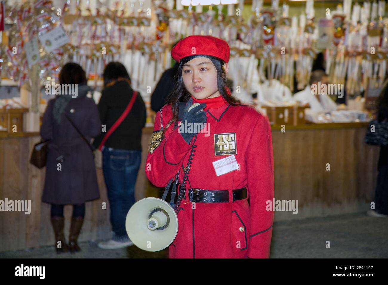 Pretty female Japanese security guard with megaphone standing in front ...