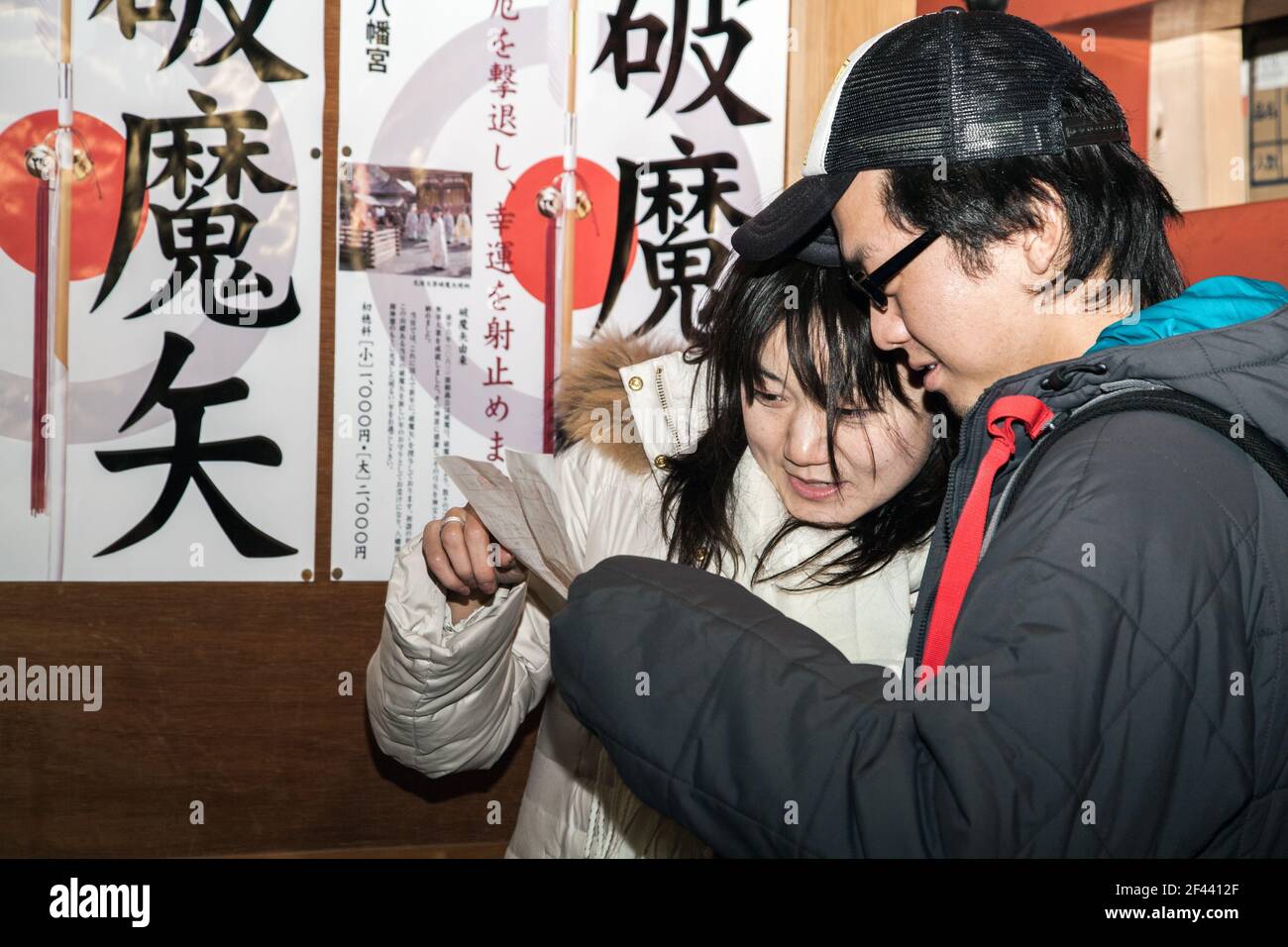Japanese couple read their omikuji - fortune telling paper predicting ...