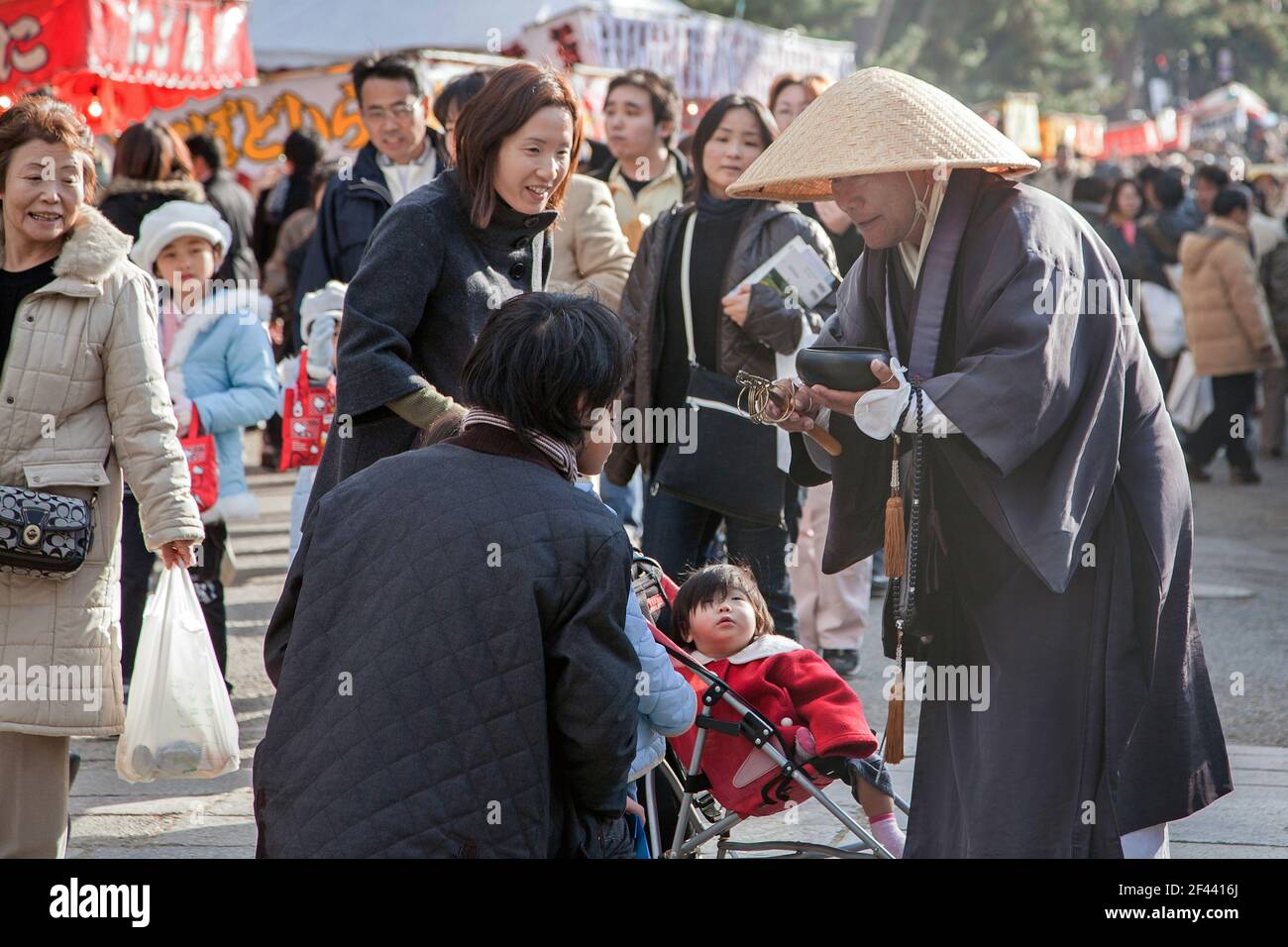 Buddhist monk with his ceremonial shakujo stick giving blessings to a ...