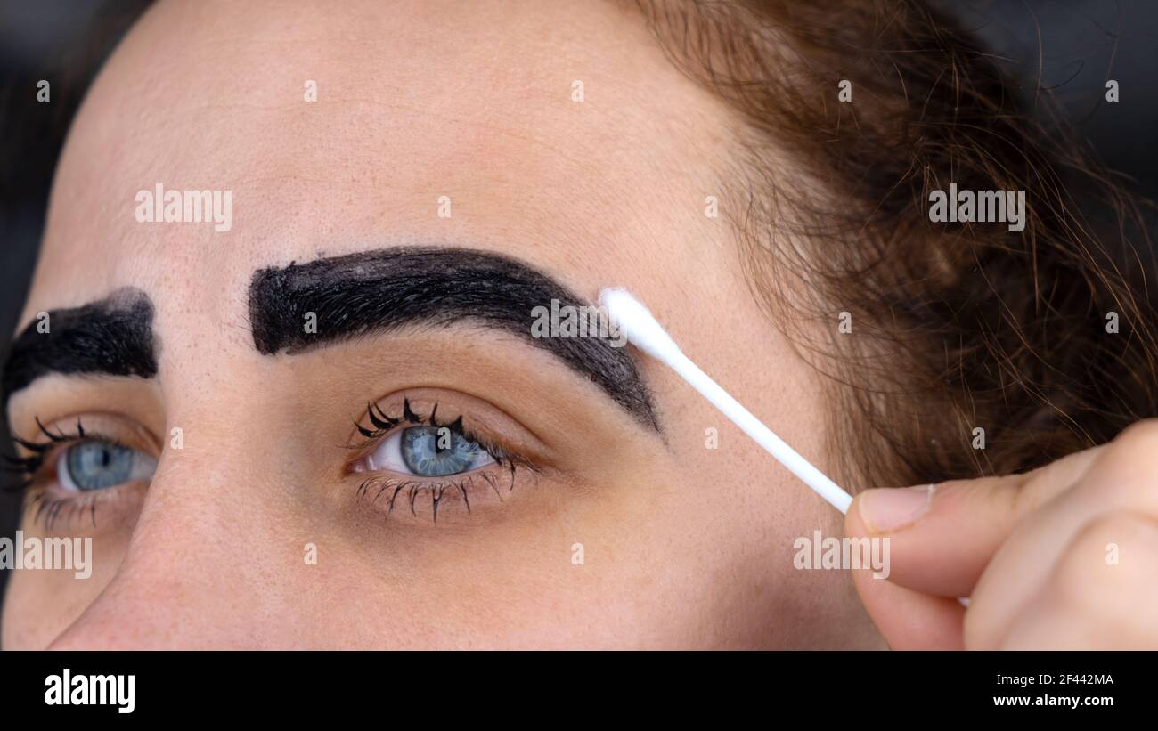 eyebrow dyeing procedure, girl wipes paint from her eyebrows Stock ...