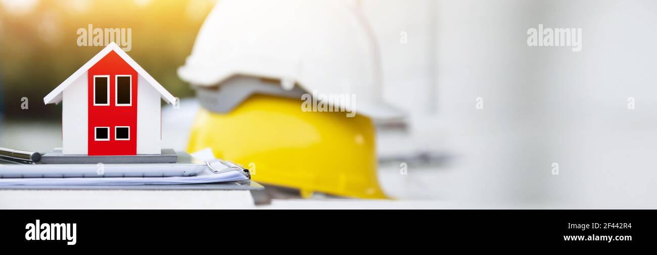 Home model on site building with helmet hard hat safety in construction ...