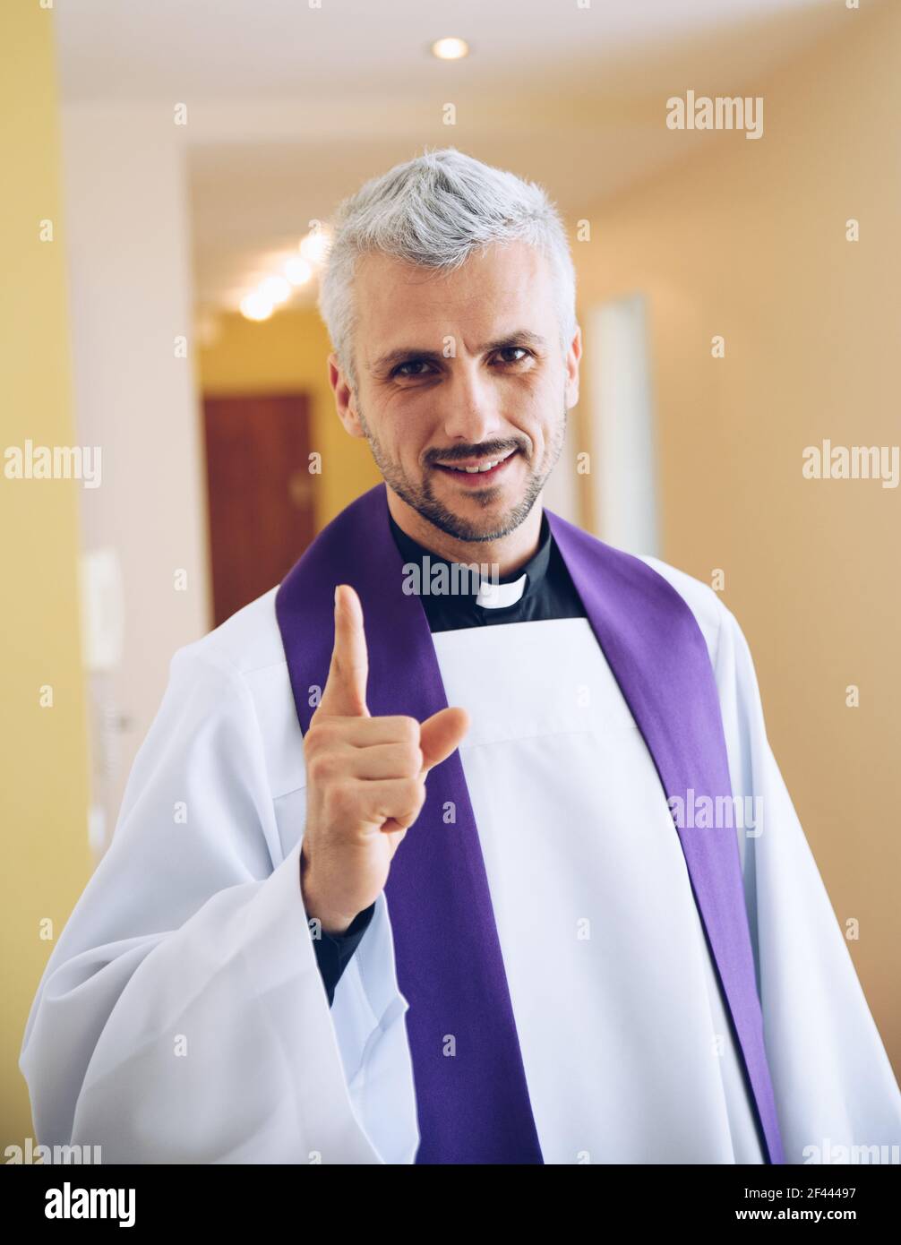 Priest male pointing finger up to heaven Stock Photo - Alamy