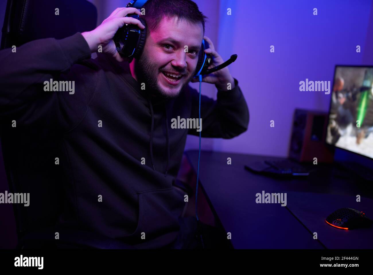 Gamer or streamer in headphones with microphone sits at home and plays ...