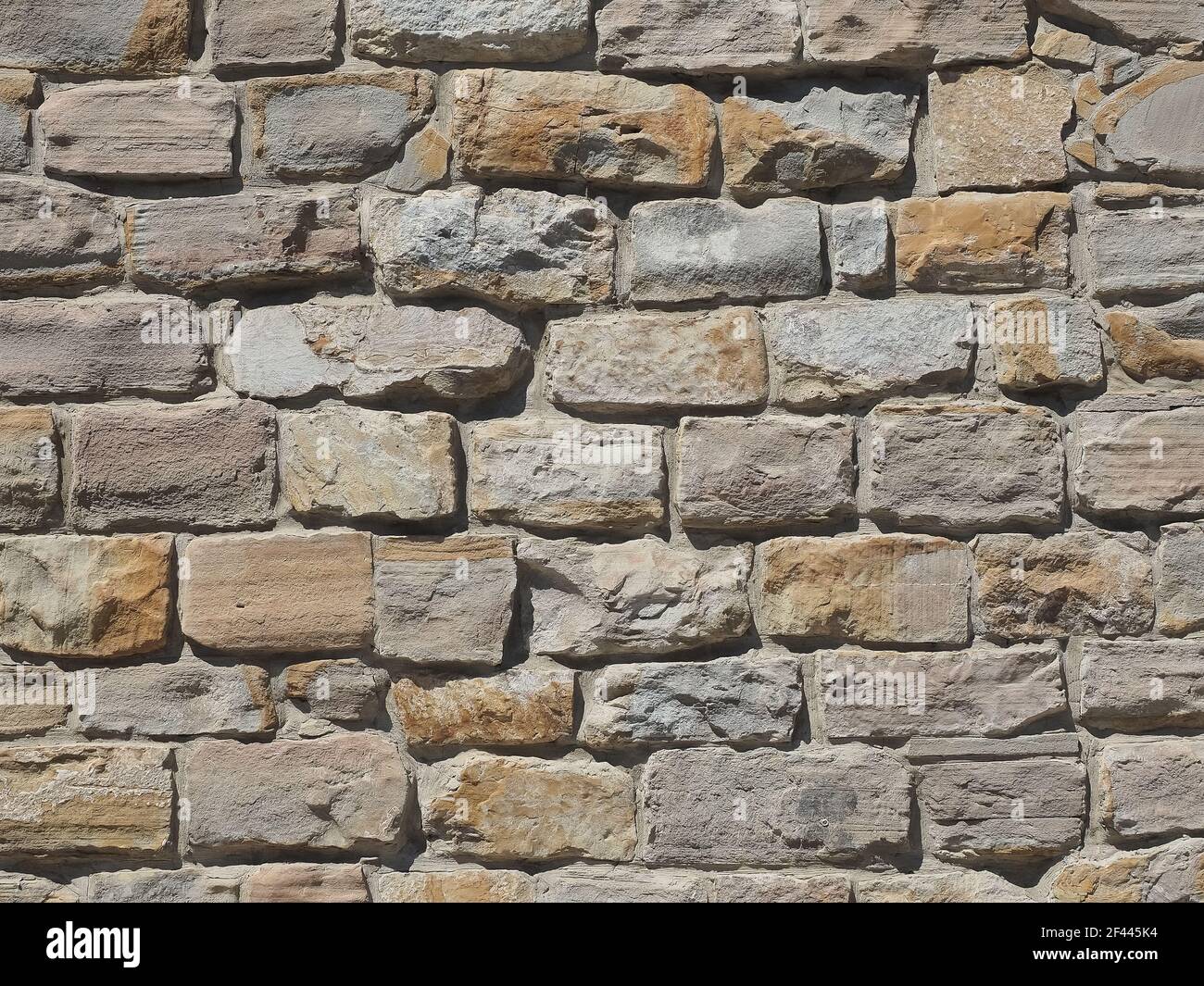 Rough masonry wall with broken and cracked parts illuminated by ...