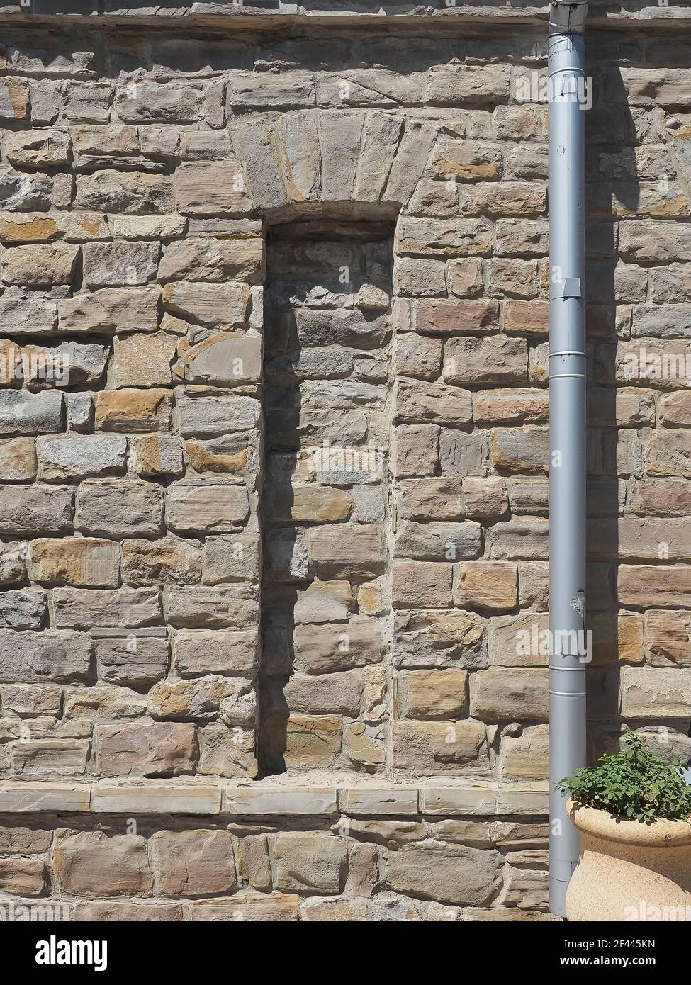 The outer wall of building with rough masonry and a decorative recess ...