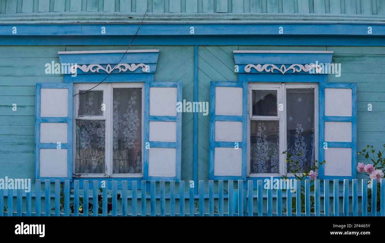 Russian old blue log cabin with blue shutters and fence near Lake ...