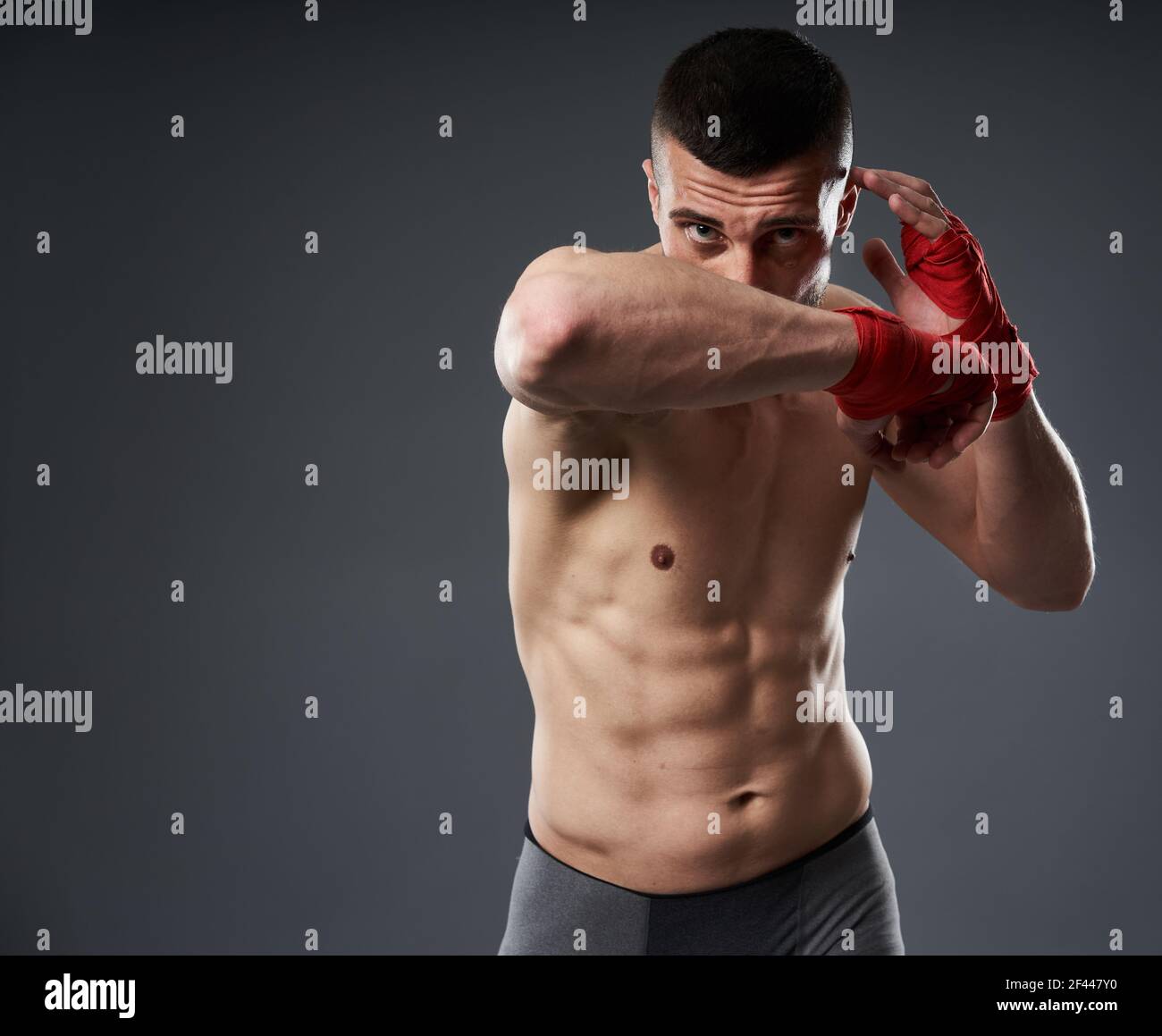 MMA fighter training, throwing an elbow strike, isolated on gray ...