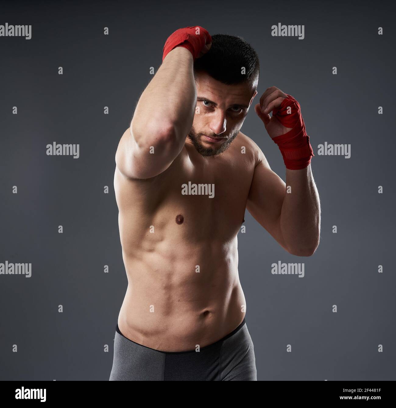 MMA fighter training, throwing an elbow strike, isolated on gray ...
