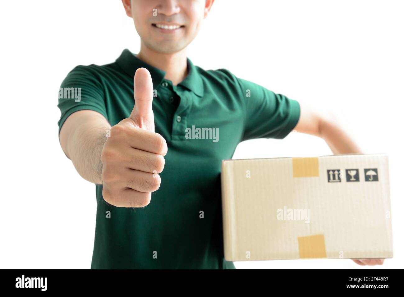 Deliveryman carrying a parcel box giving thumbs up Stock Photo - Alamy