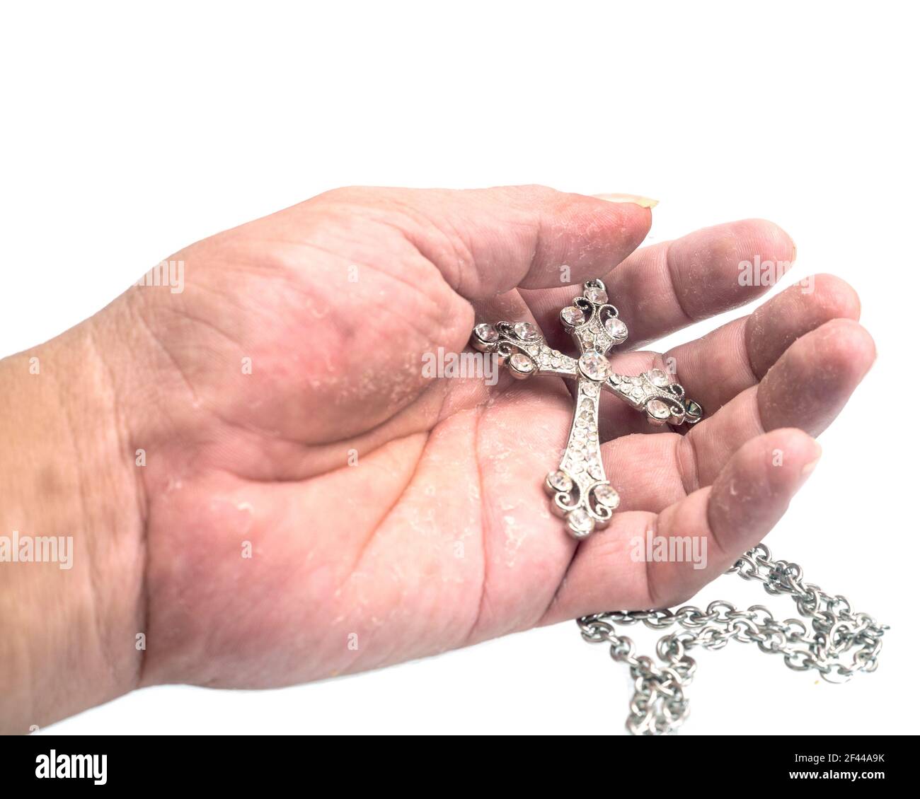 Man's hand with christian cross in hands isolated on a white background ...