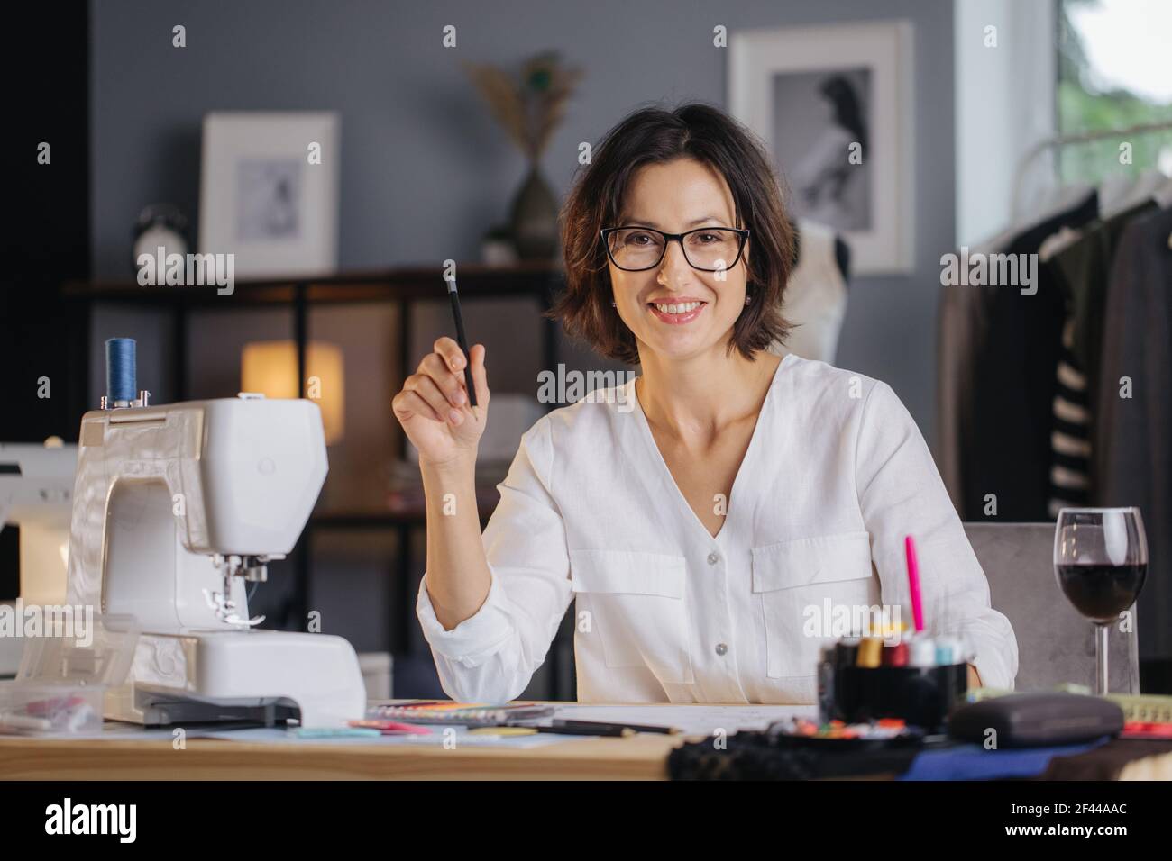Smiling dressmaker drawing a sketches at studio Stock Photo - Alamy