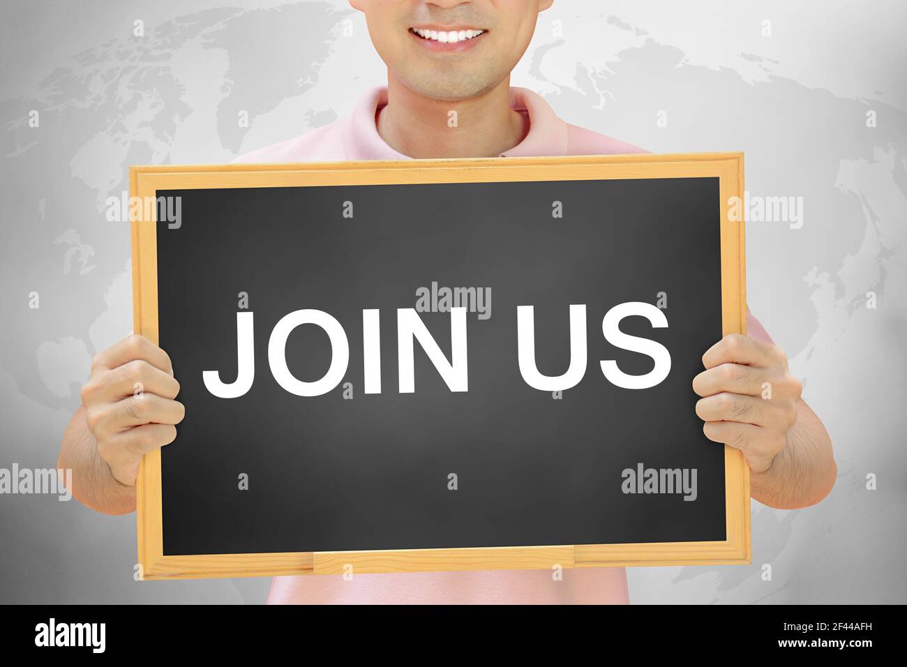 JOIN US sign on blackboard held by smiling man Stock Photo - Alamy