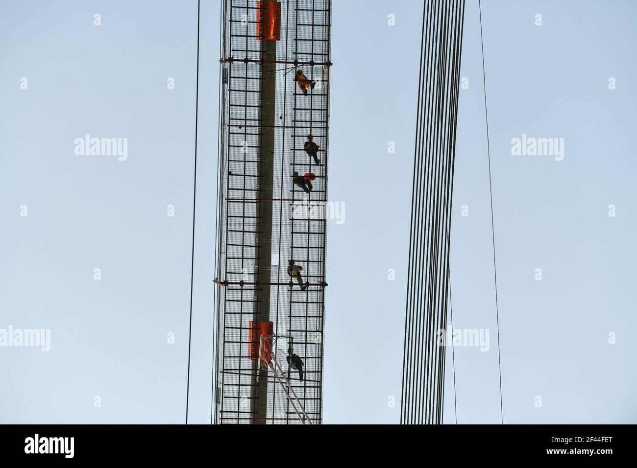 Guiding. 17th Mar, 2021. Workers walk on a catwalk at the construction ...