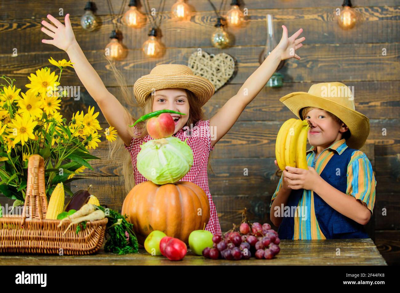 Celebrate harvest holiday. Children play vegetables wooden background ...