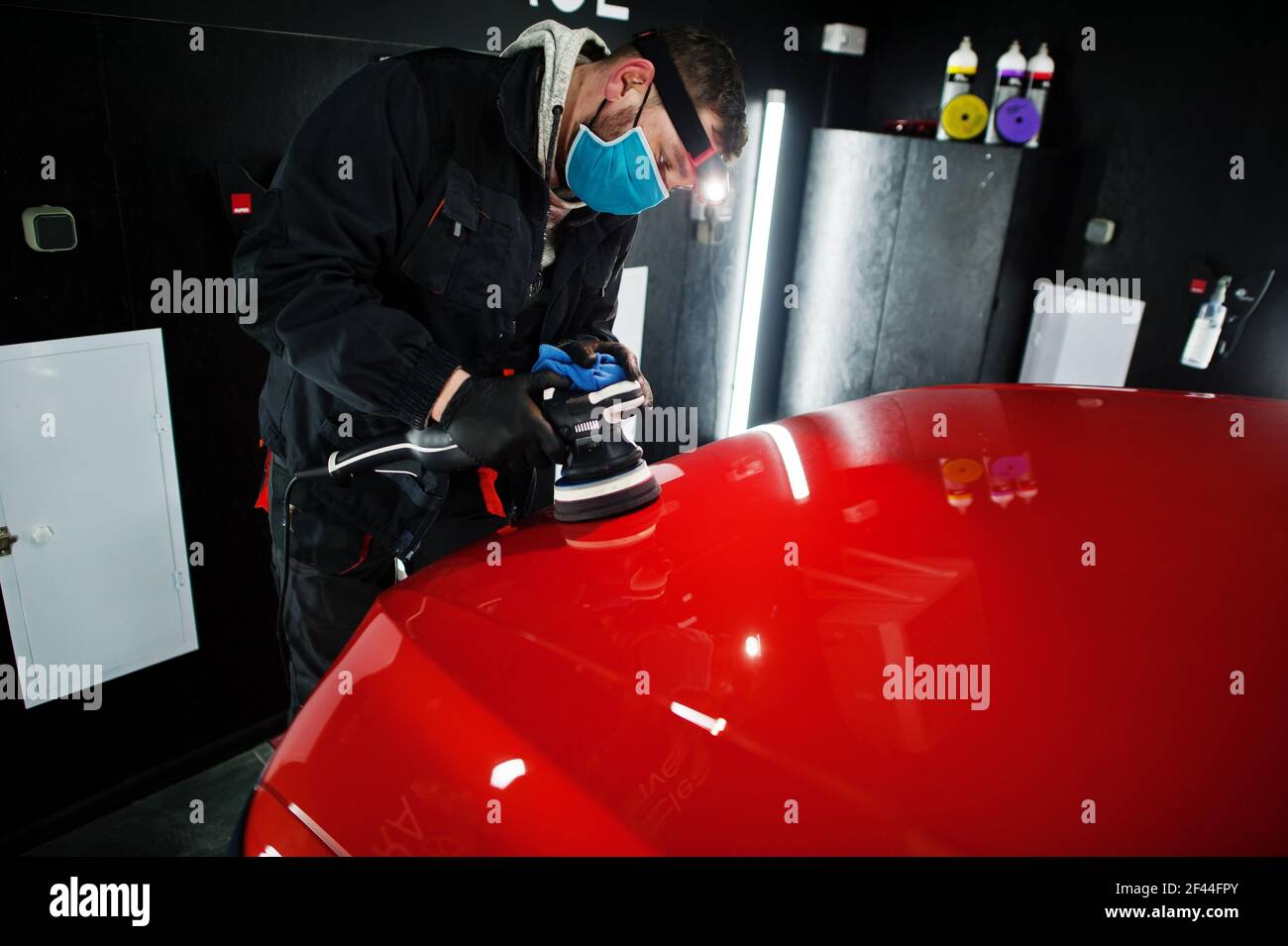 Car detailing concept. Man in face mask with orbital polisher in repair ...