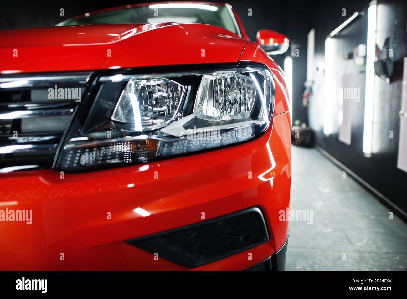 Headlight of nice and new orange sport suv car in modern garage Stock ...