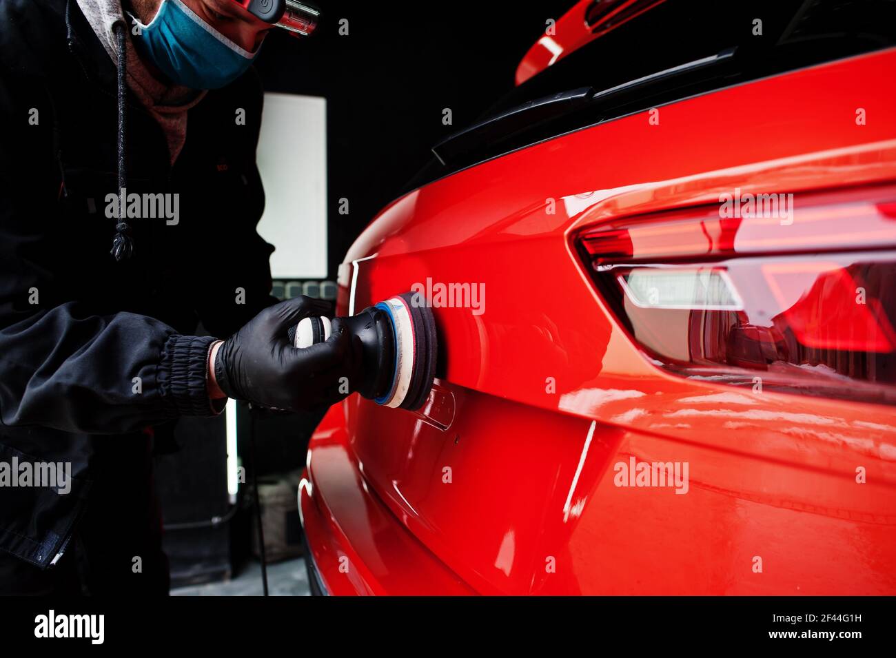 Car detailing concept. Man in face mask with orbital polisher in repair ...